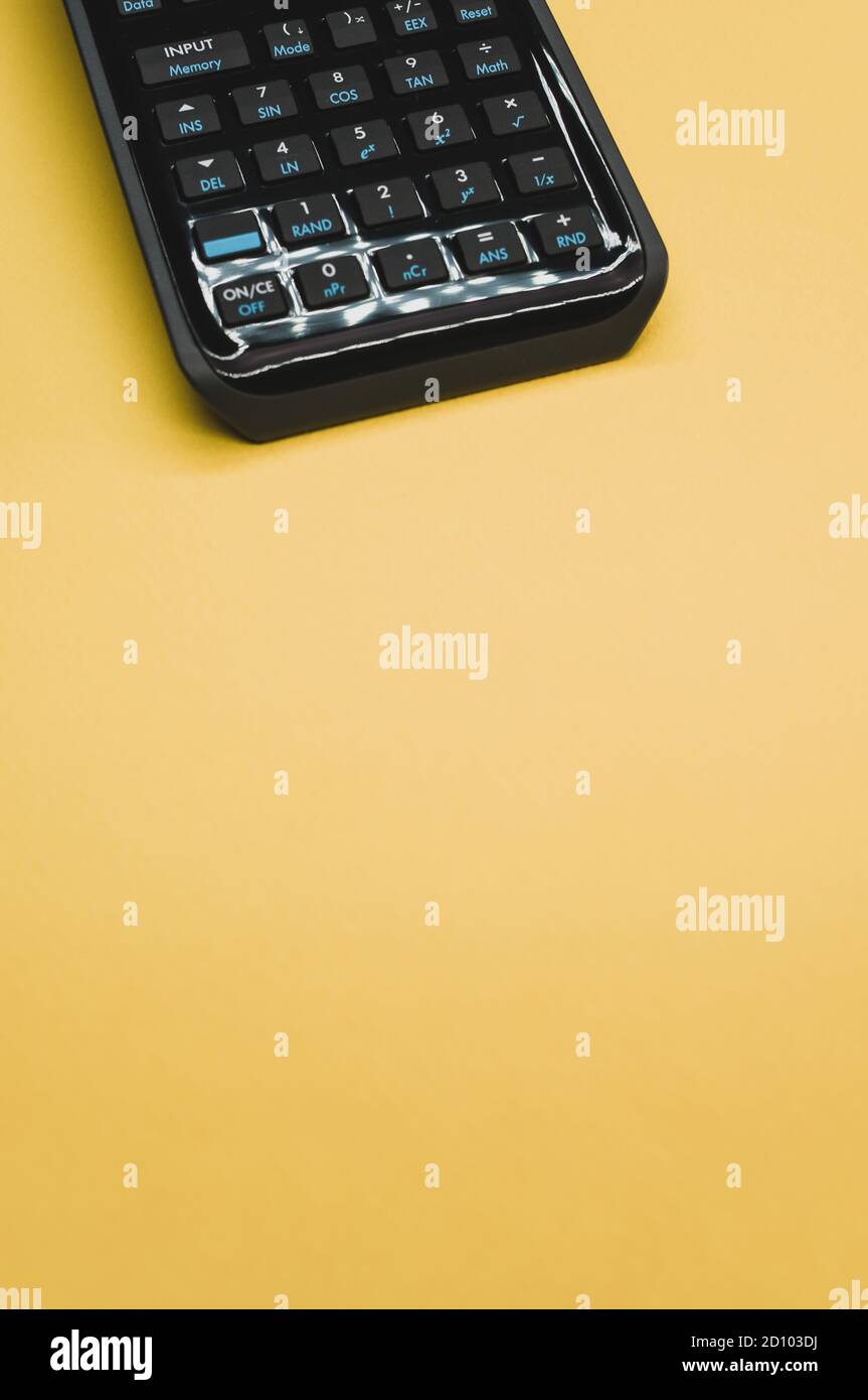 Vertical shot of a scientific calculator on pastel yellow background ...