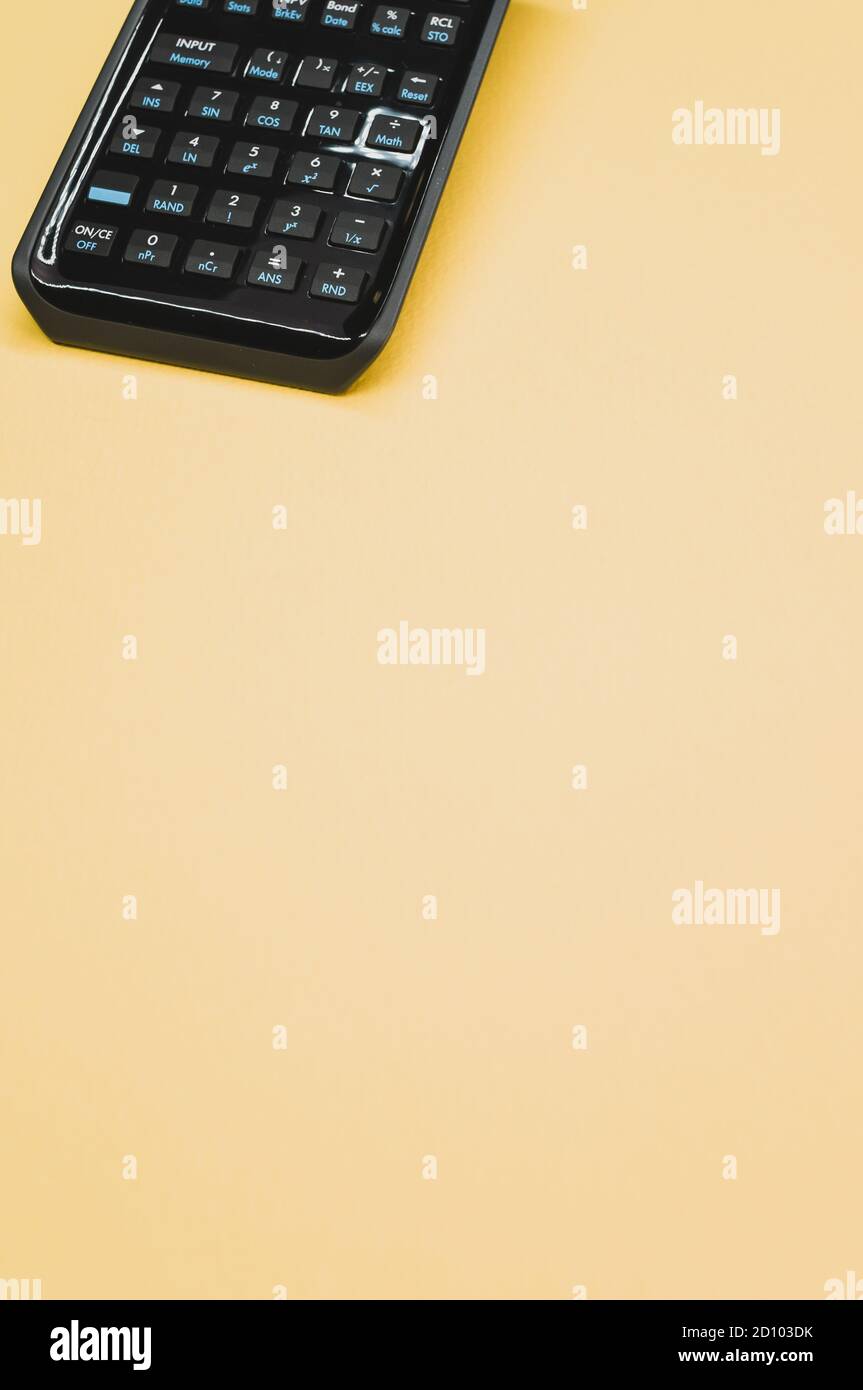 Vertical shot of a scientific calculator on pastel yellow background ...