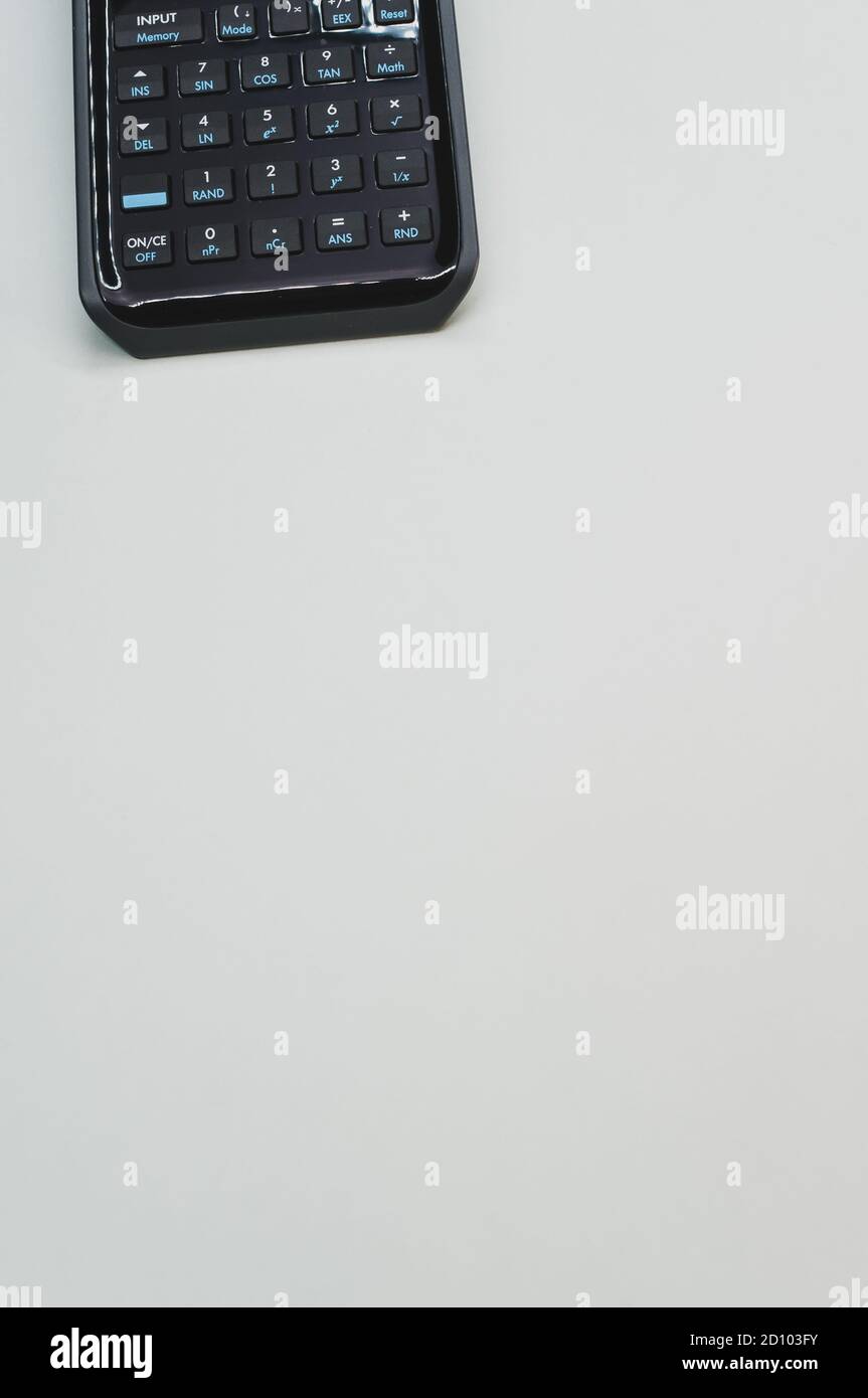Vertical shot of a scientific calculator on pastel gray background with ...
