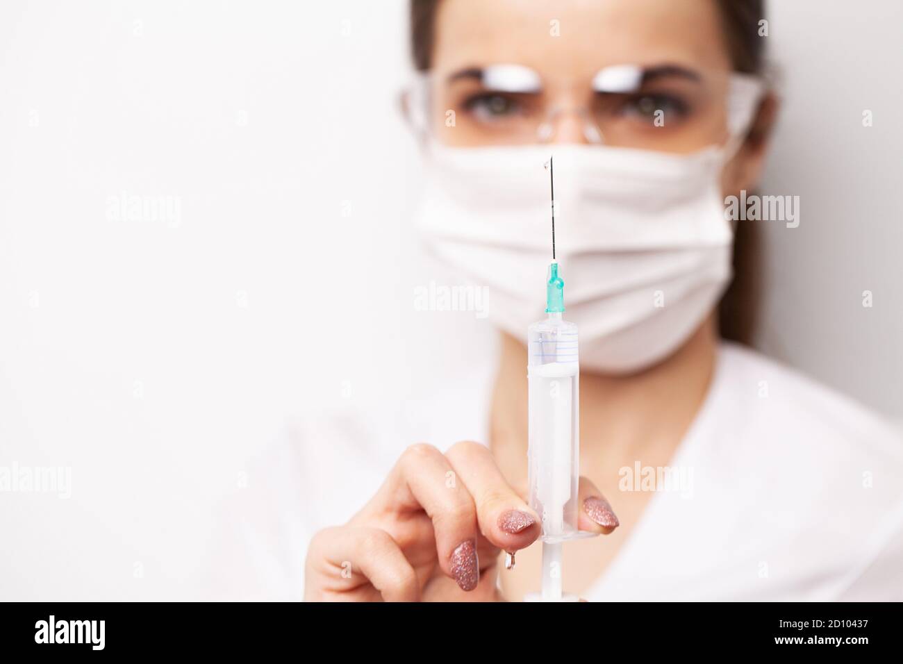 Woman holding medical injection syringe in her outstretched hand ...