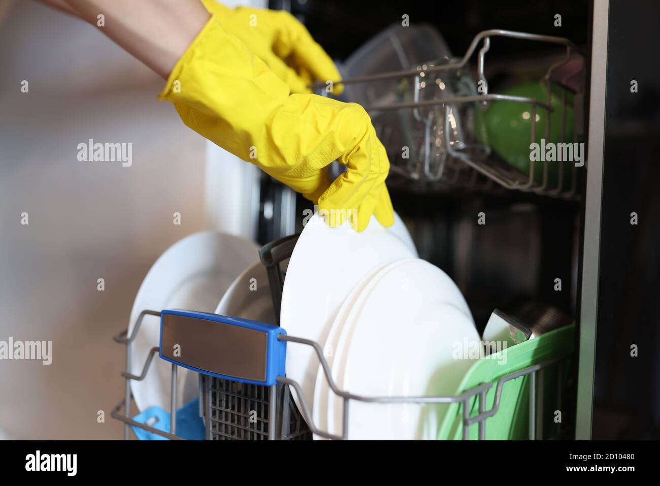 Hand in yellow glove take out washed kitchen utensil Stock Photo - Alamy