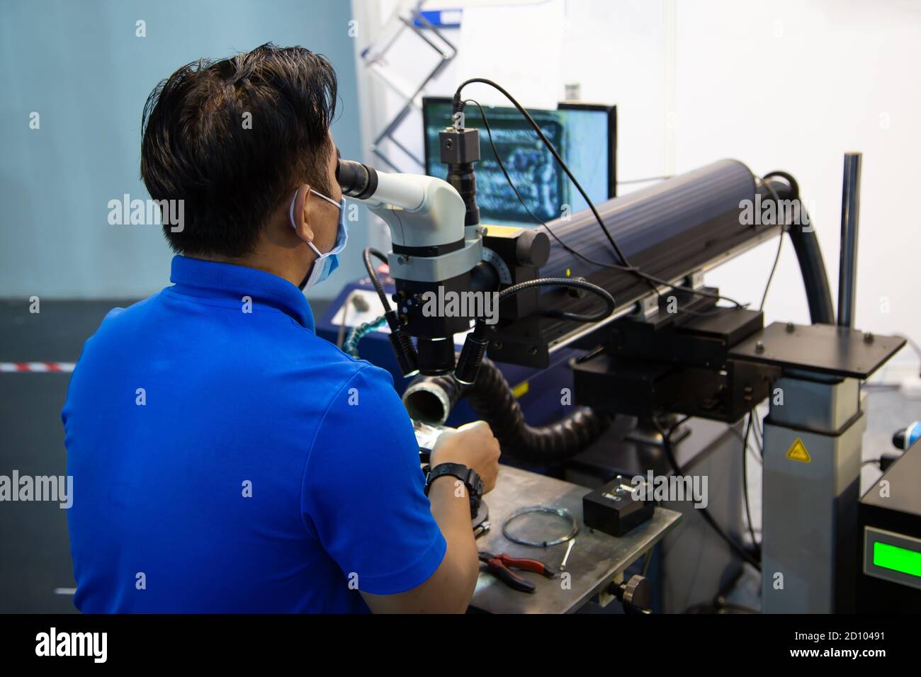 Industrial professional wearing face mask operating laser welding ...