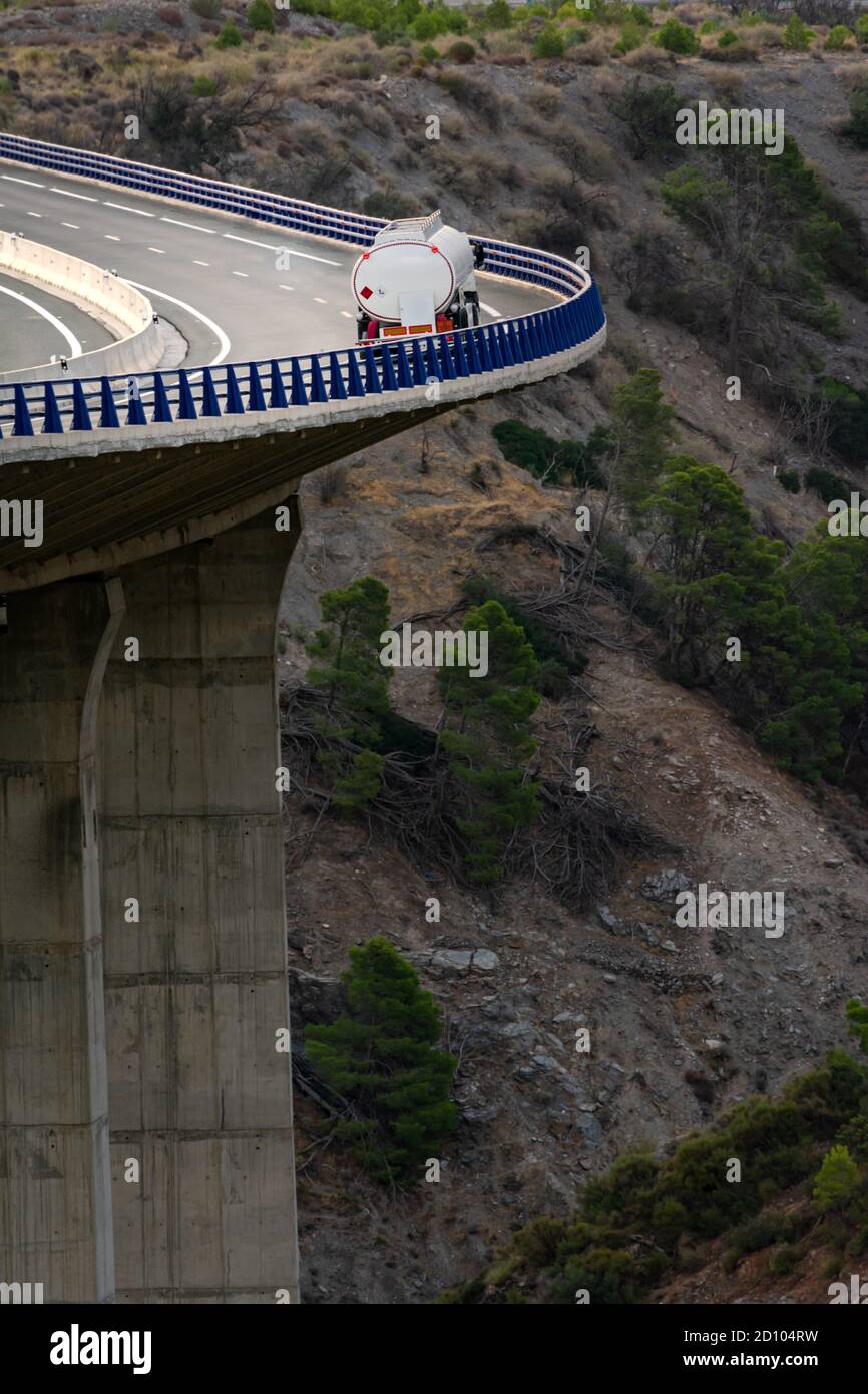 Fuel tanker driving over a curved bridge revealing the void under the ...