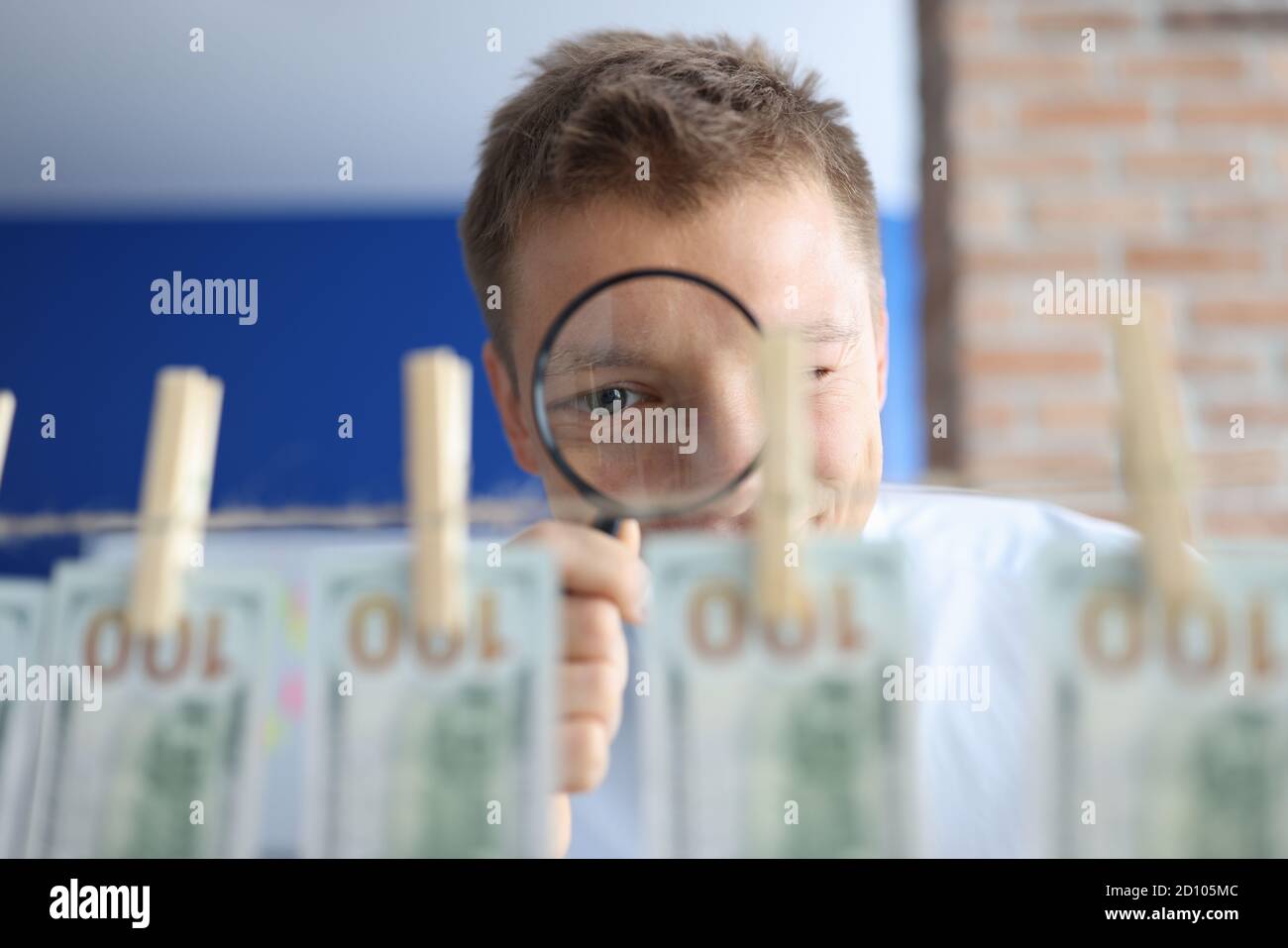Man examines money through magnifying glass Stock Photo - Alamy