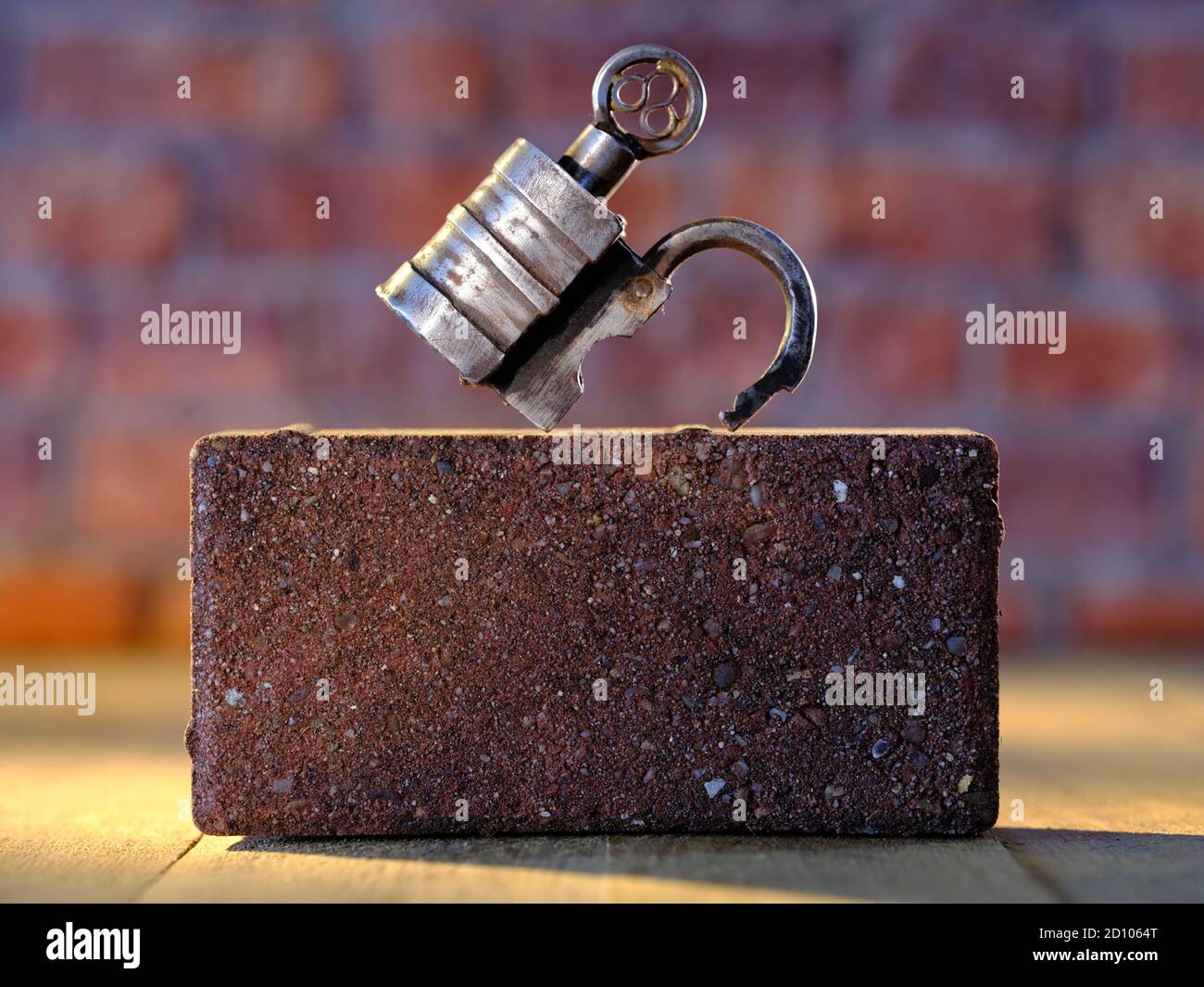 Vintage Barrel Padlock with screw key resting on brick with brick ...