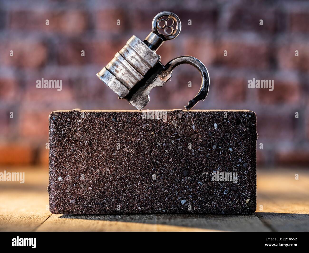 Vintage Barrel Padlock with screw key resting on brick with brick ...