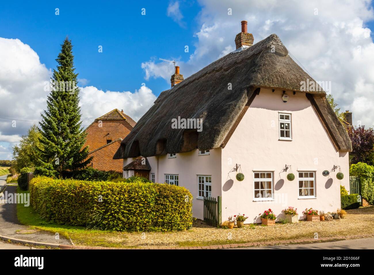 A thatched pink cottage on a rural country lane in Great Bedwyn, a ...