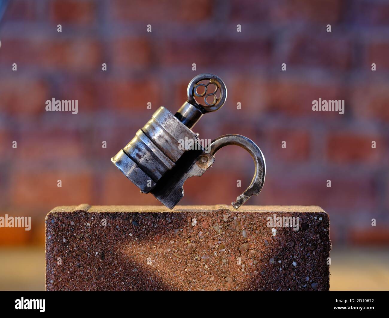 Vintage Barrel Padlock with screw key resting on brick with brick ...