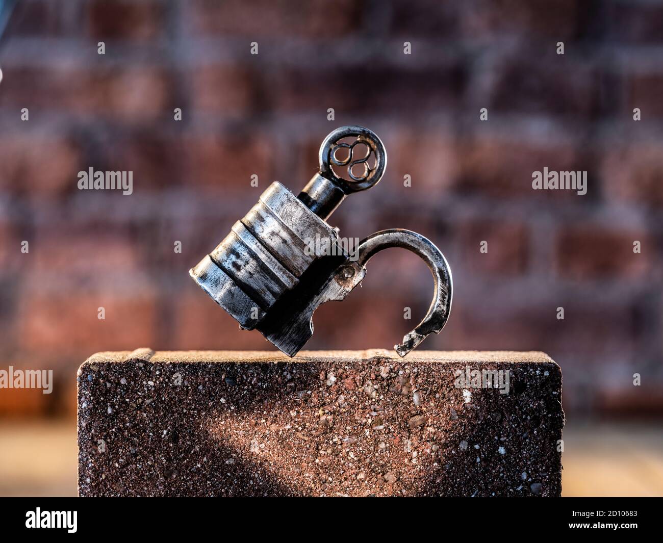 Vintage Barrel Padlock with screw key resting on brick with brick ...