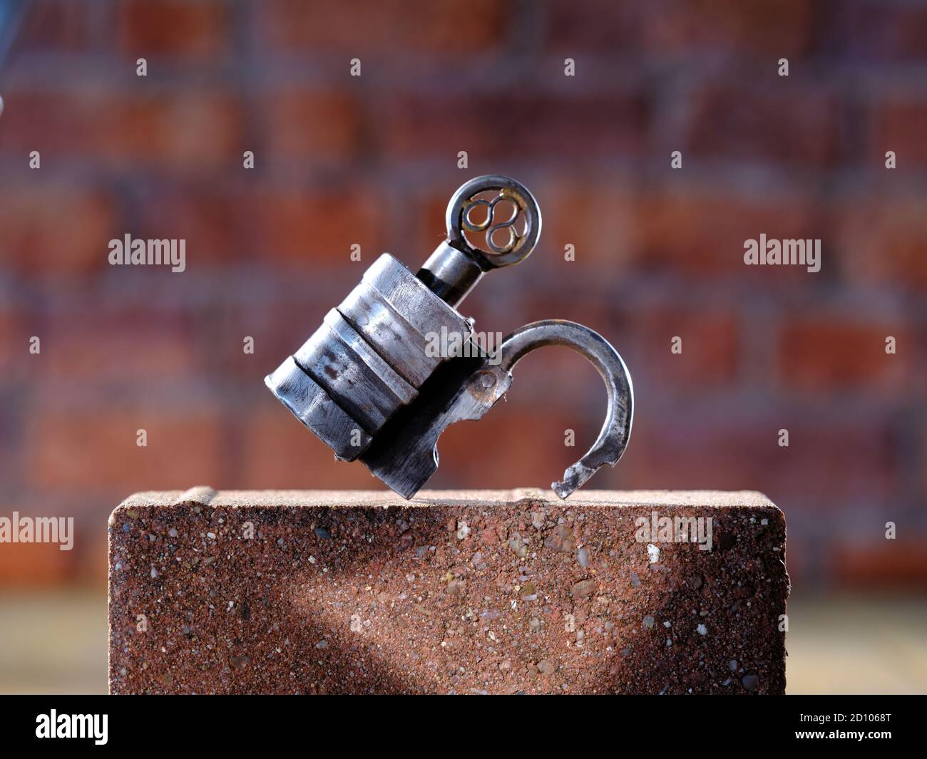Vintage Barrel Padlock with screw key resting on brick with brick ...