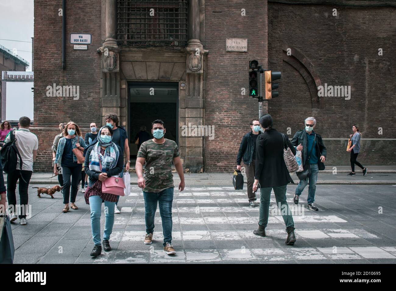 Bologna: people with masks observe social distancing at the traffic ...