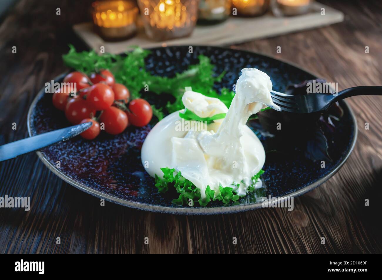 traditional Italian dish is burrata cheese . Burrata on a fork is ...