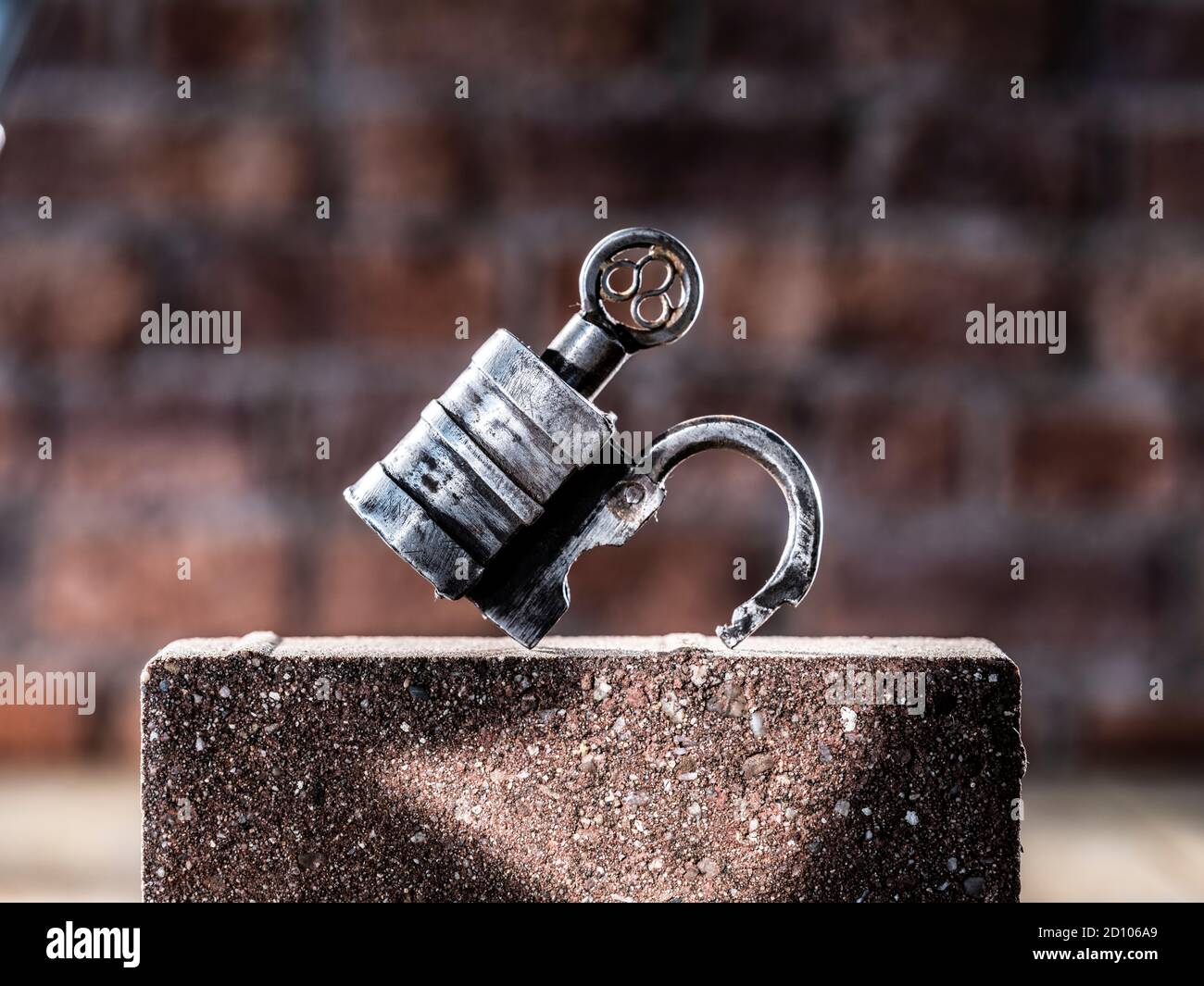 Vintage Barrel Padlock with screw key resting on brick with brick ...