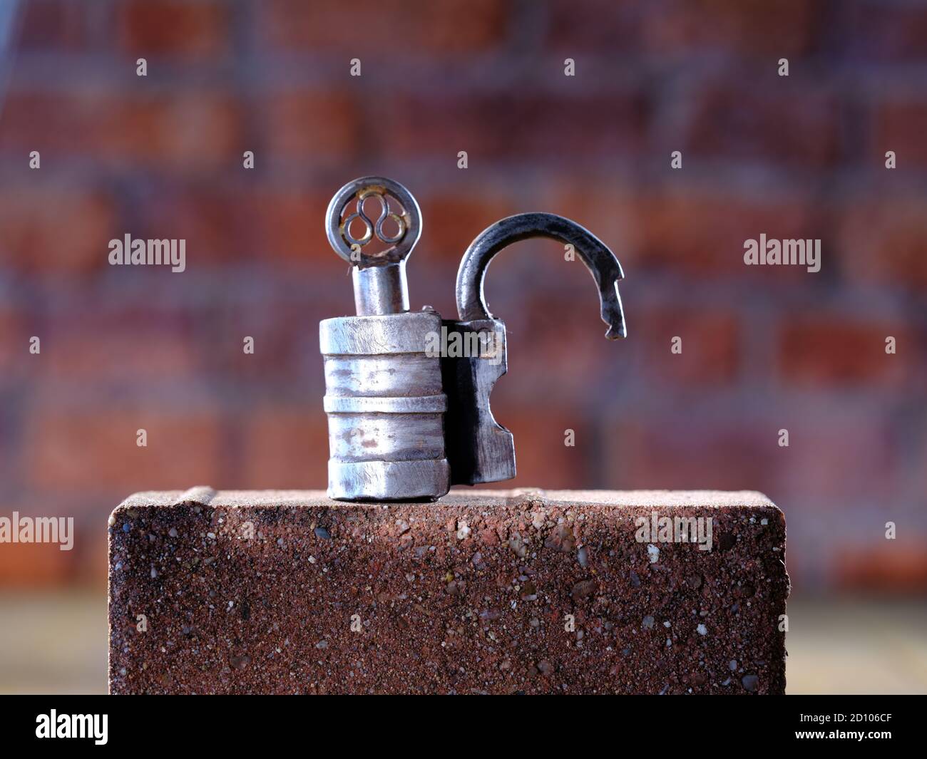 Vintage Barrel Padlock with screw key resting on brick with brick ...