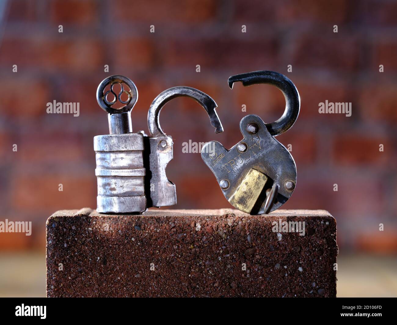 Vintage Barrel Padlock with screw key resting on brick with brick ...