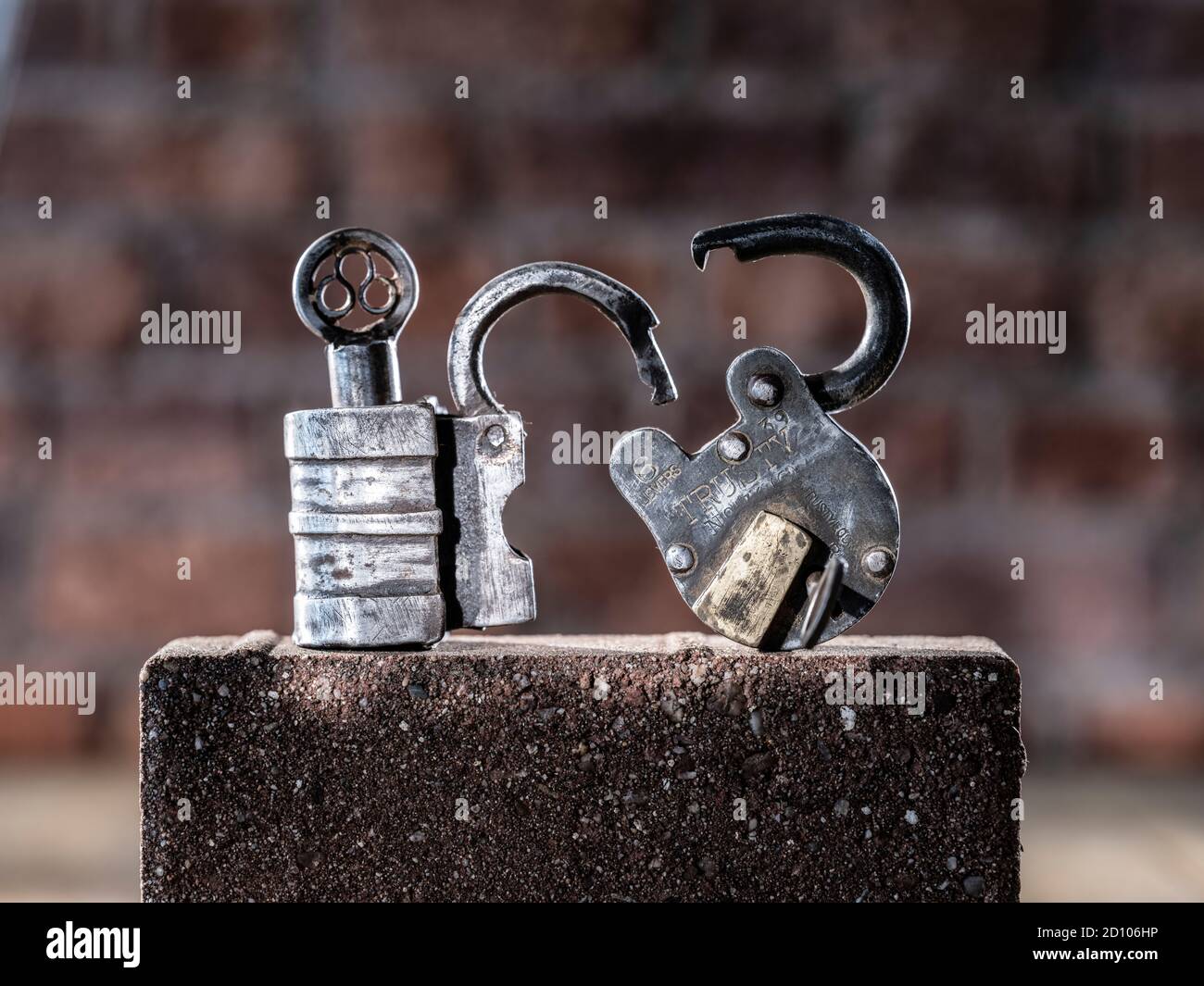 Vintage Barrel Padlock with screw key resting on brick with brick ...