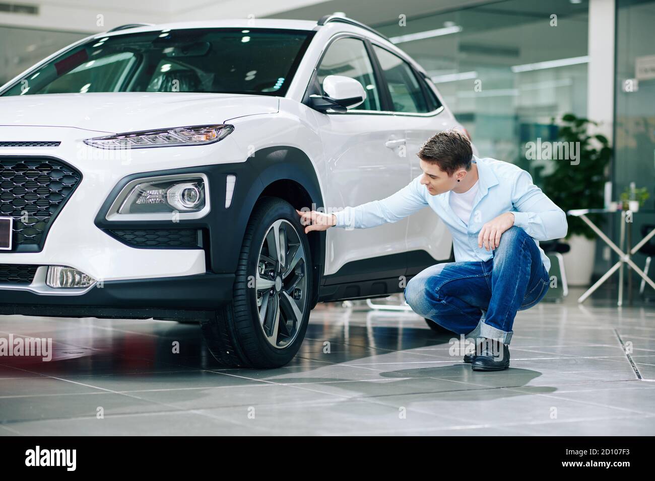 Man checking car tires Stock Photo - Alamy