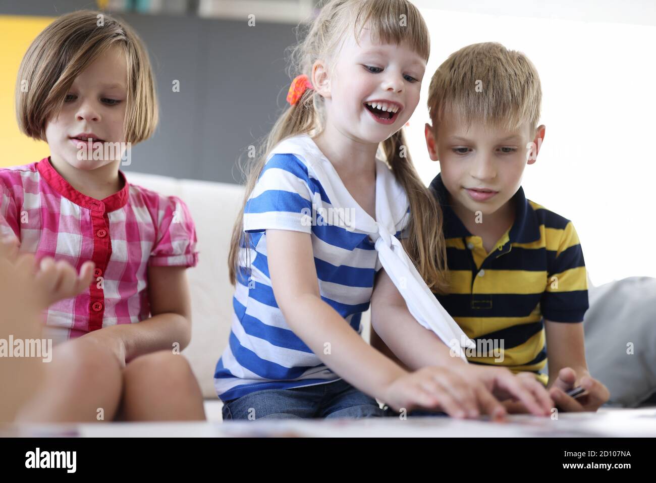 Happy girl take playing card from table Stock Photo - Alamy