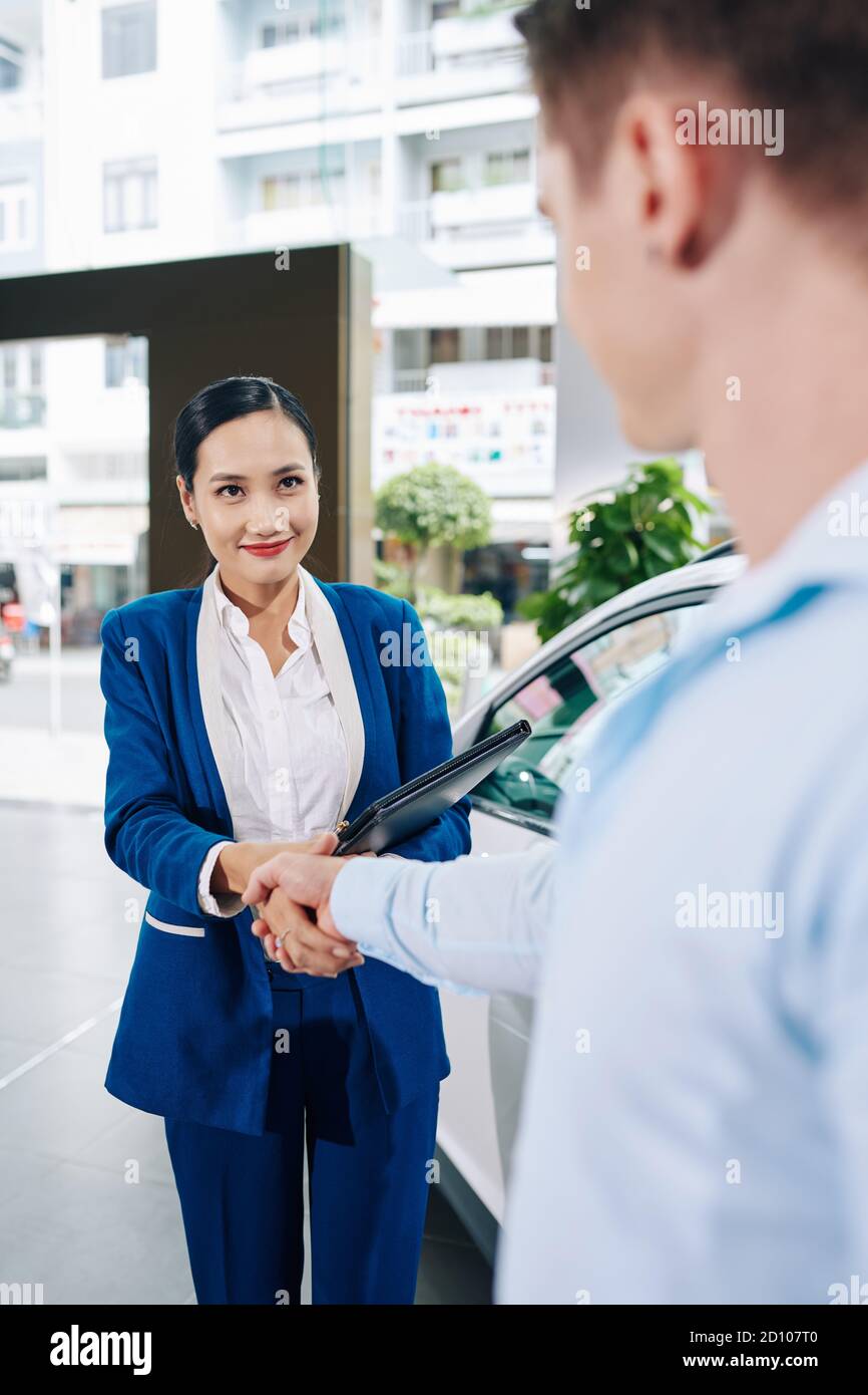 Saleswoman greeting customer Stock Photo - Alamy