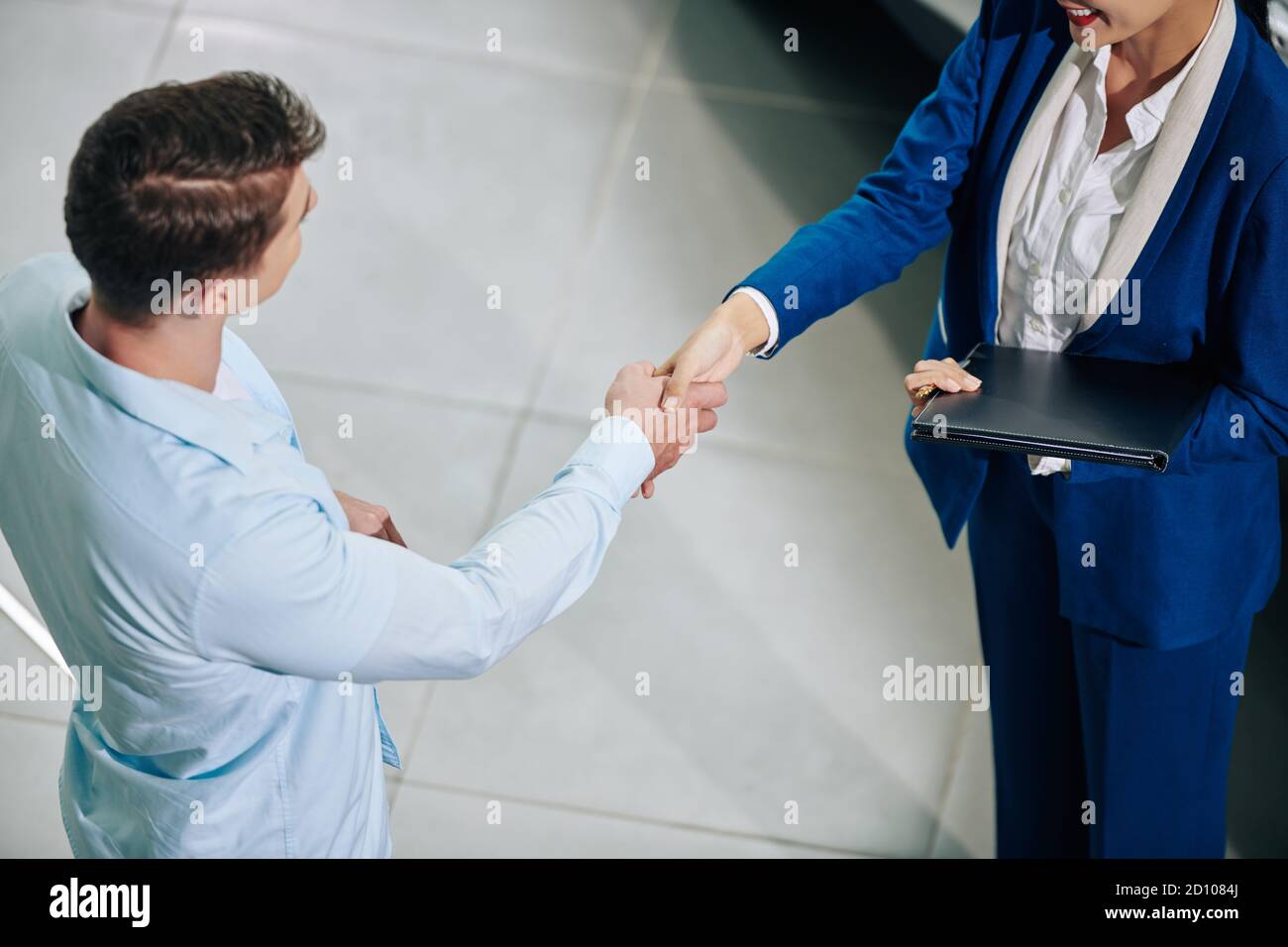 Greeting customer in car dealership Stock Photo - Alamy