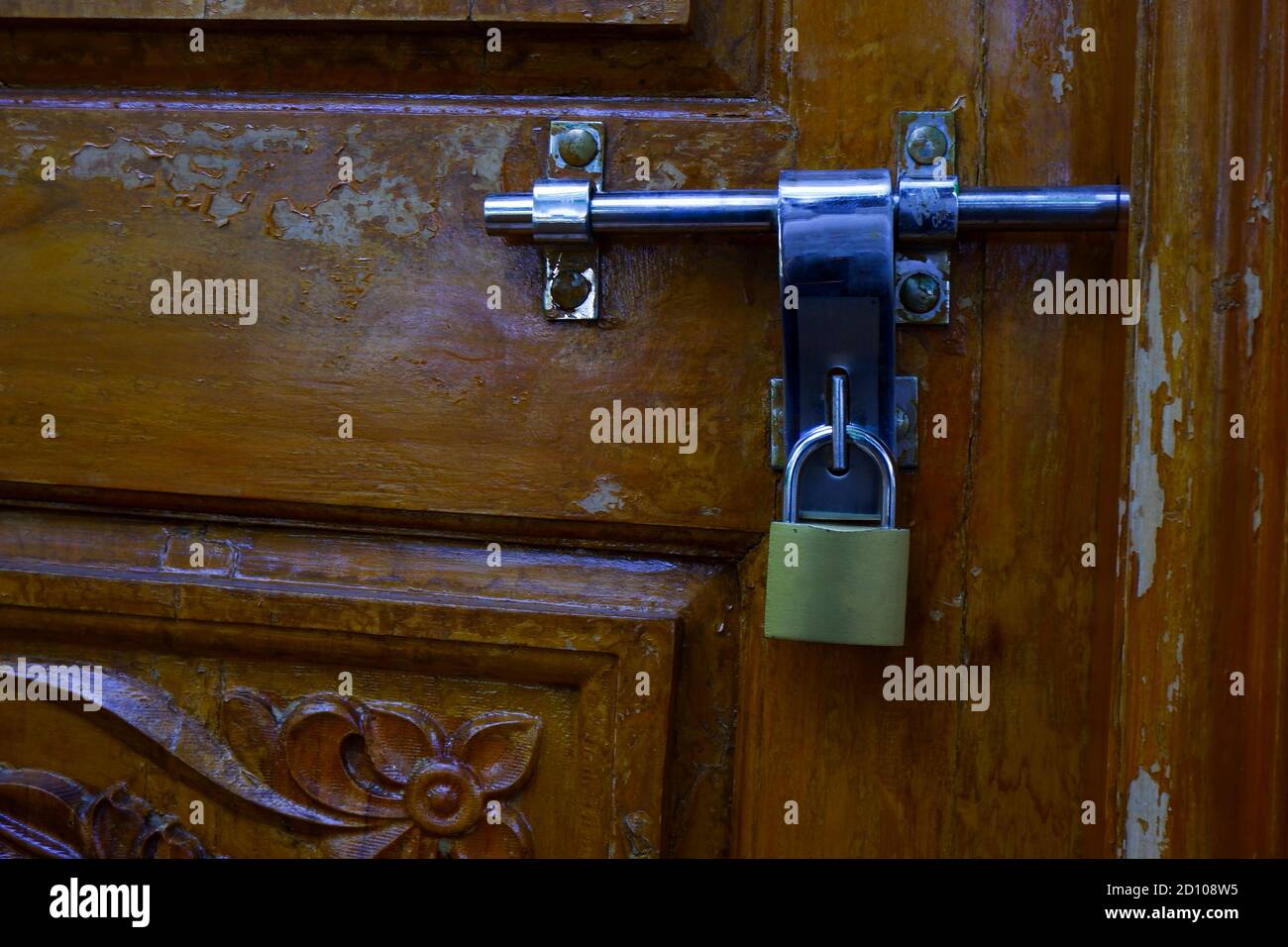 a close shot of locked padlock isolated on wooden door Stock Photo - Alamy