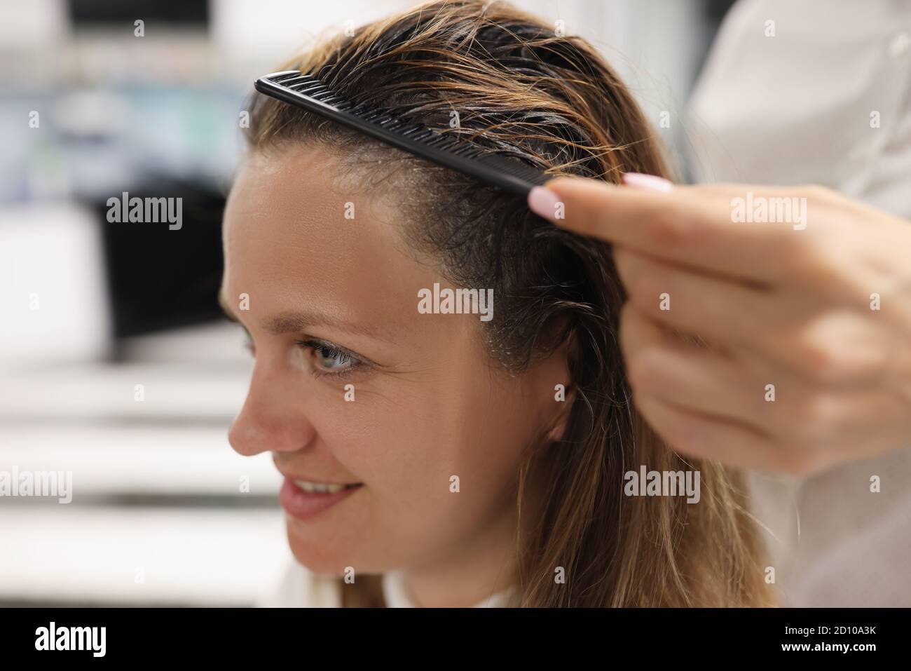 Hairdresser comb dyed hair in beauty salon Stock Photo - Alamy