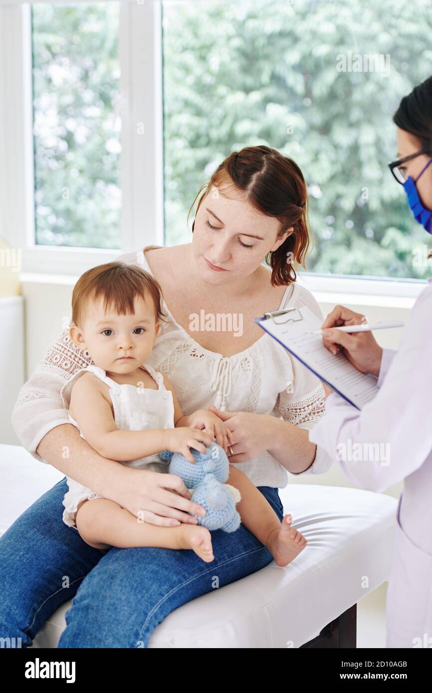 Pediatrician filling medical card Stock Photo - Alamy