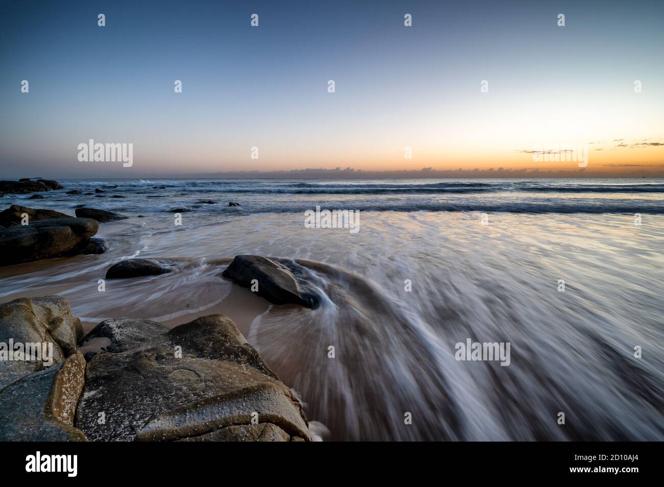 Fascinating shot of a wavy shore on background of the sunset on a ...