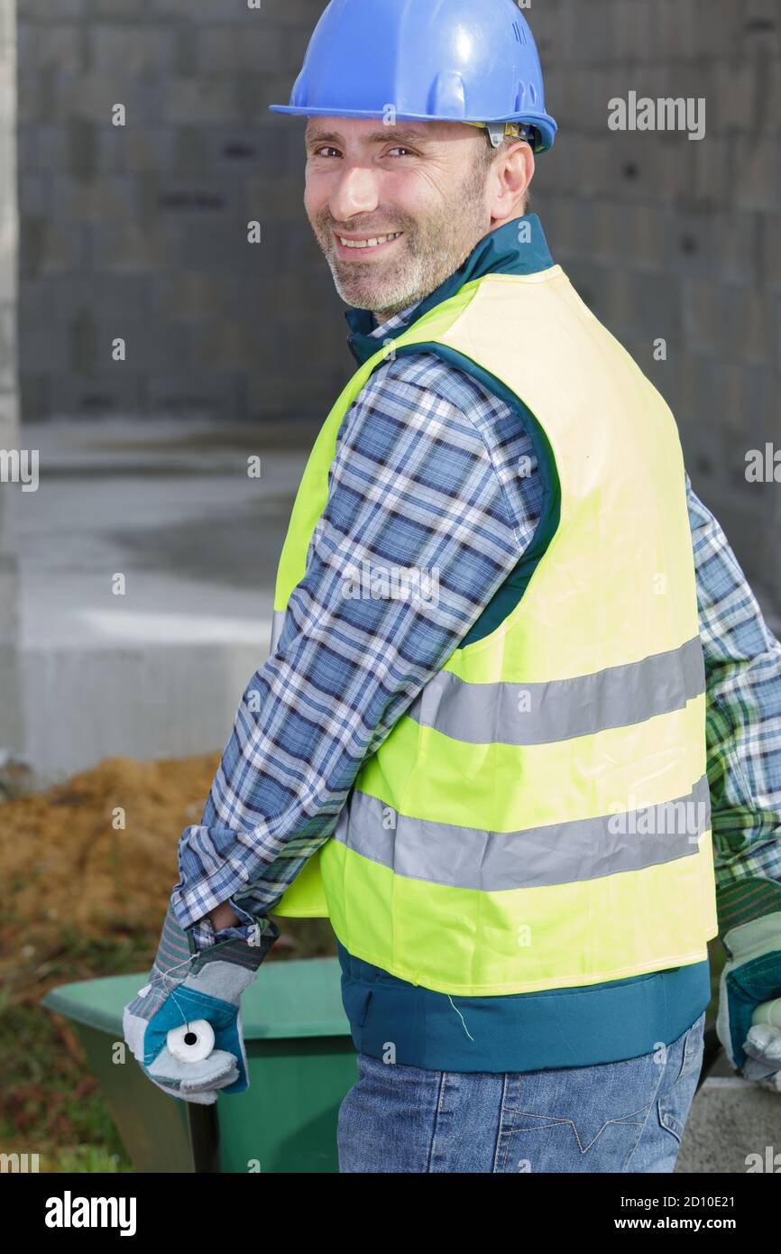 builder carrying blocks on a wheelbarrow at the construction site Stock ...