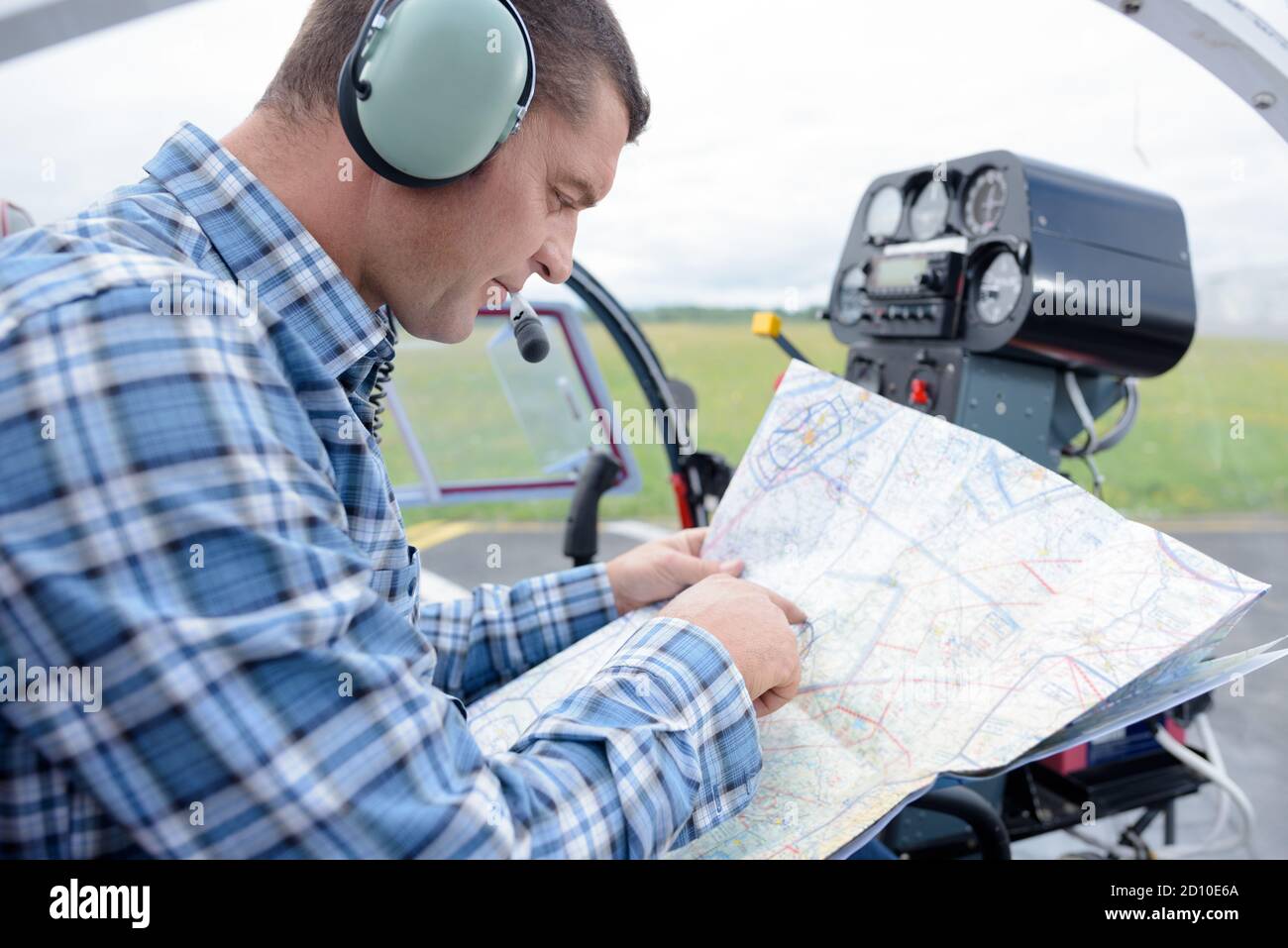 pilot in a helicopter looking at map Stock Photo - Alamy