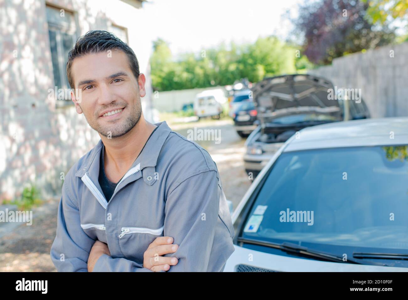 Mechanic stood outside, arms crossed Stock Photo - Alamy