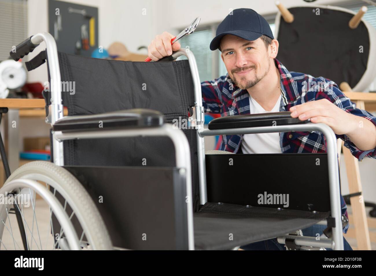man is repairing a wheelchair at workshop Stock Photo - Alamy