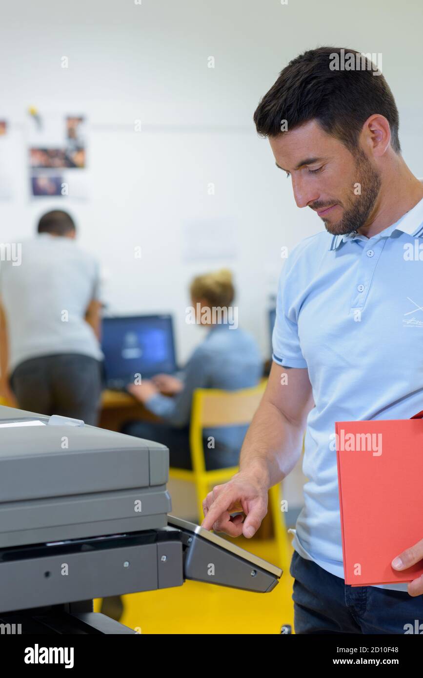 handsome and happy man using a copy machine at work Stock Photo - Alamy