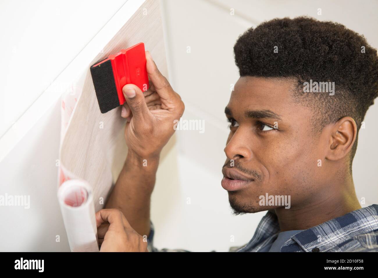 Man hanging wallpaper hi-res stock photography and images - Alamy