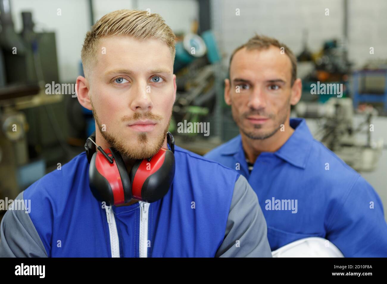 two mechanics working with different tools in a repair shop Stock Photo ...