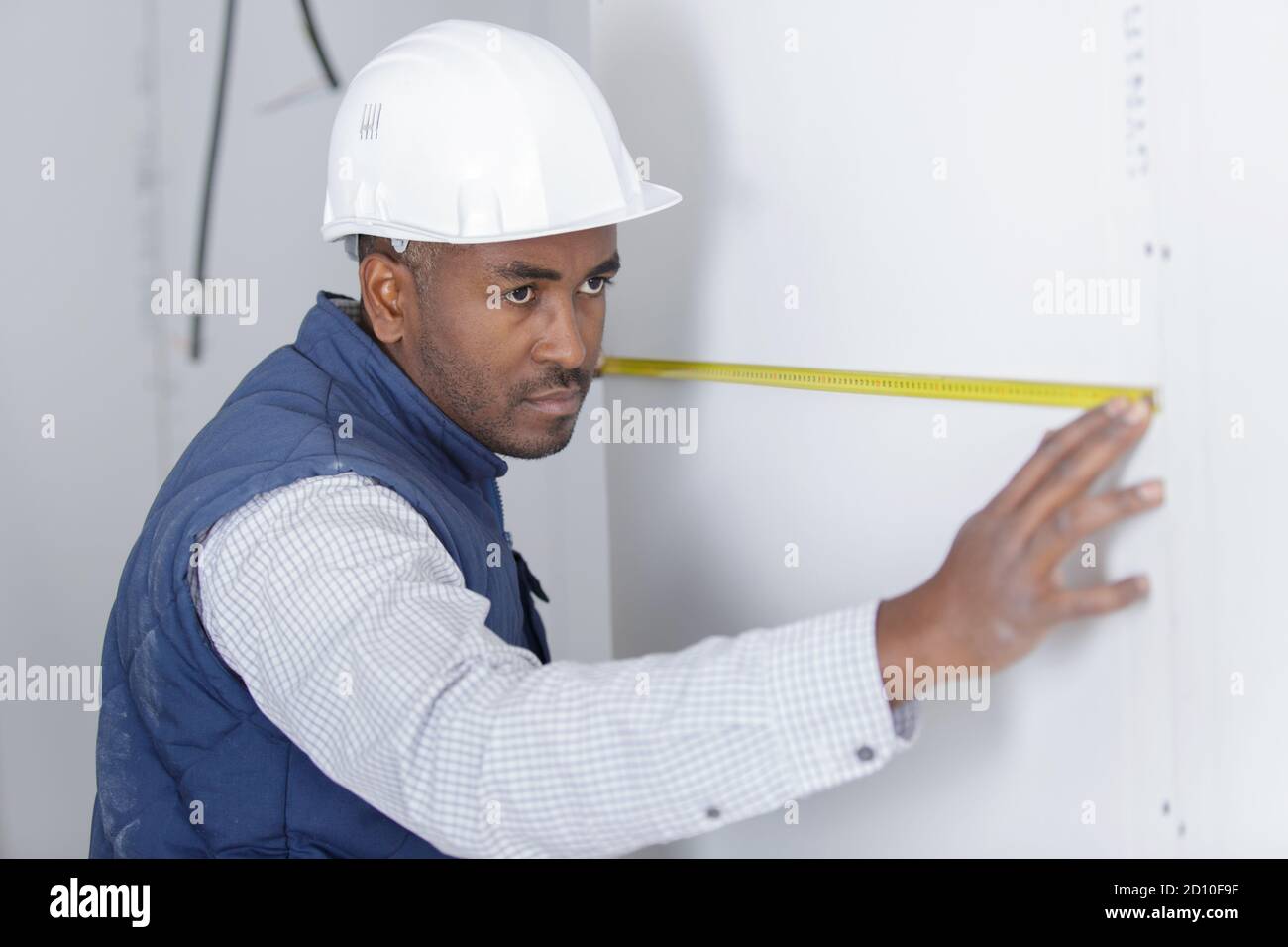man measuring the wall with a measuring tape Stock Photo - Alamy