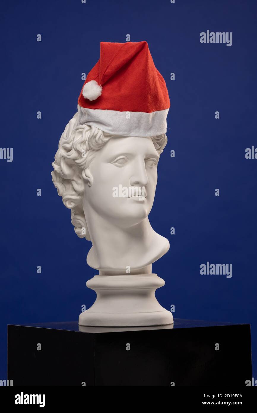White Plaster Statue of Apollo Belvedere in a red cap of Santa Claus ...