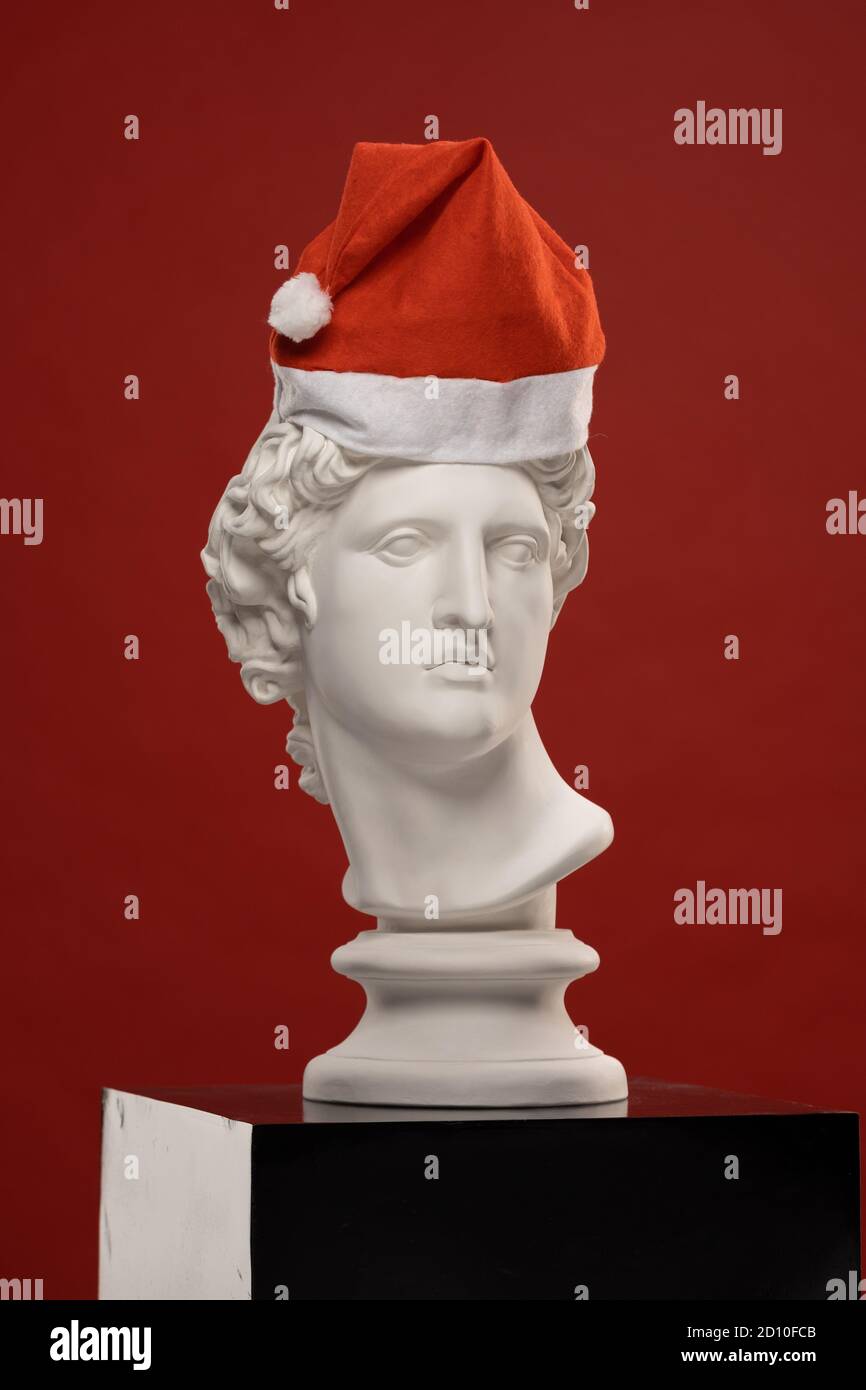White Plaster Statue of Apollo Belvedere in a red cap of Santa Claus ...