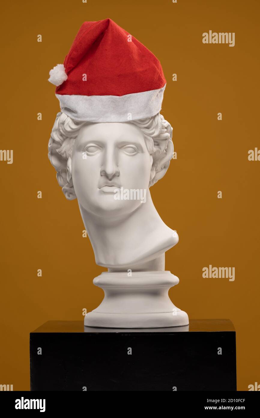 White Plaster Statue of Apollo Belvedere in a red cap of Santa Claus ...