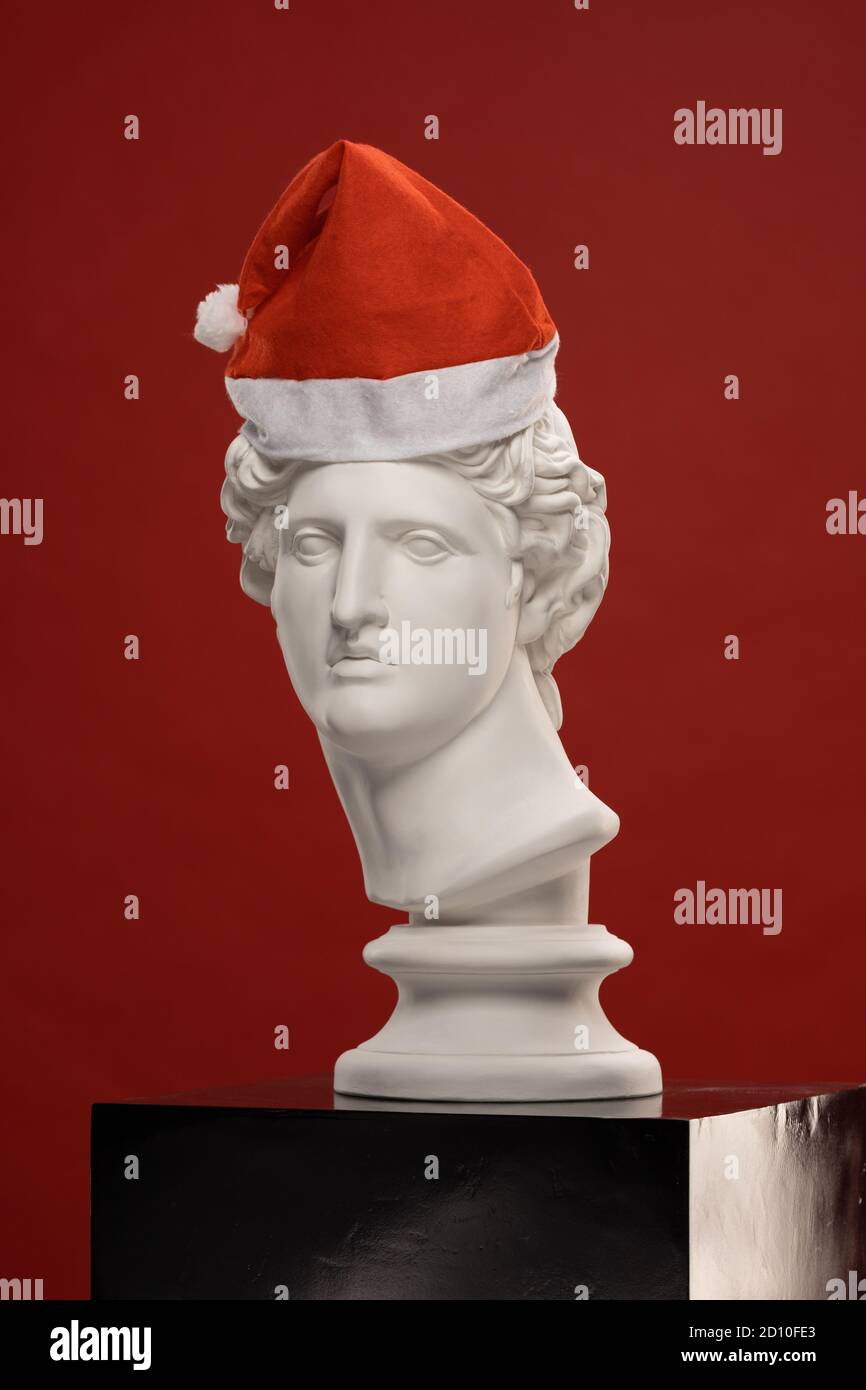 White Plaster Statue of Apollo Belvedere in a red cap of Santa Claus ...