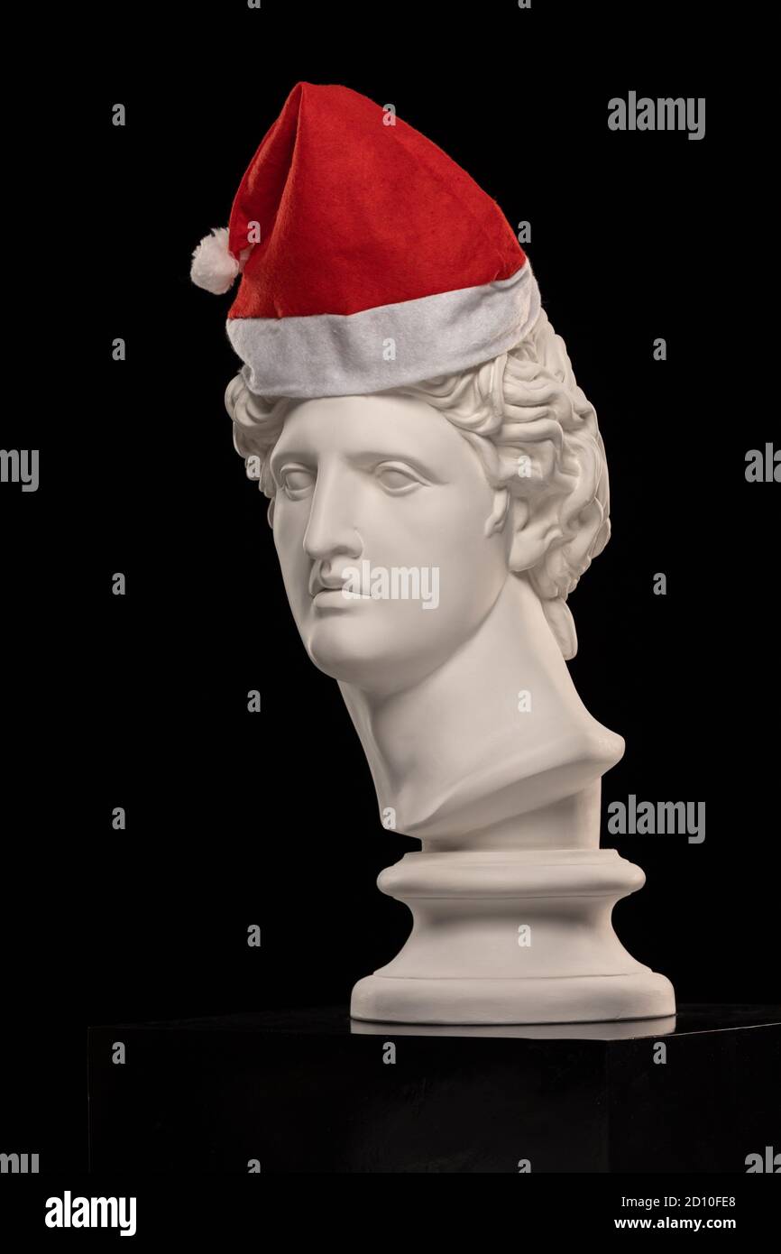White Plaster Statue of Apollo Belvedere in a red cap of Santa Claus ...