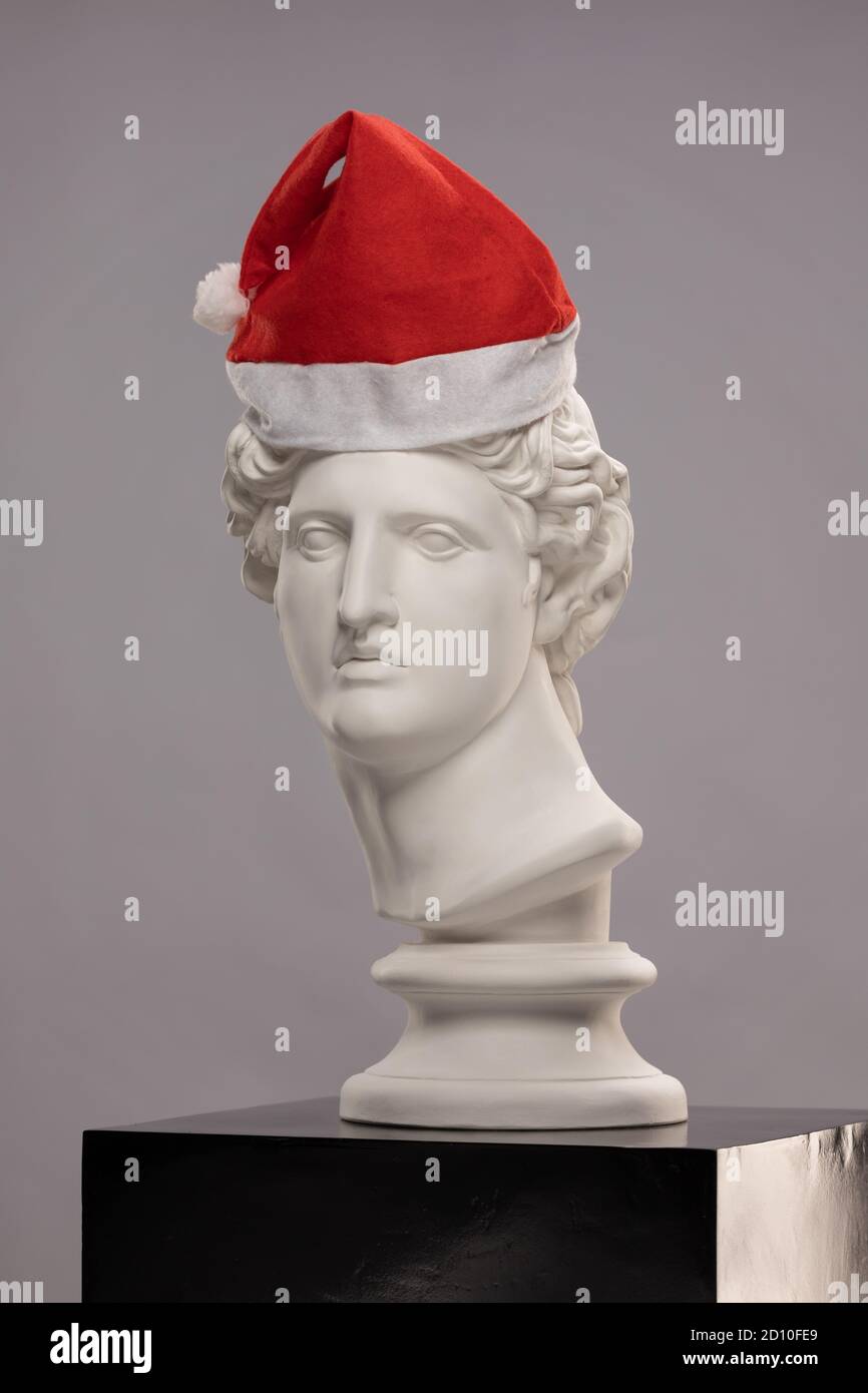White Plaster Statue of Apollo Belvedere in a red cap of Santa Claus ...