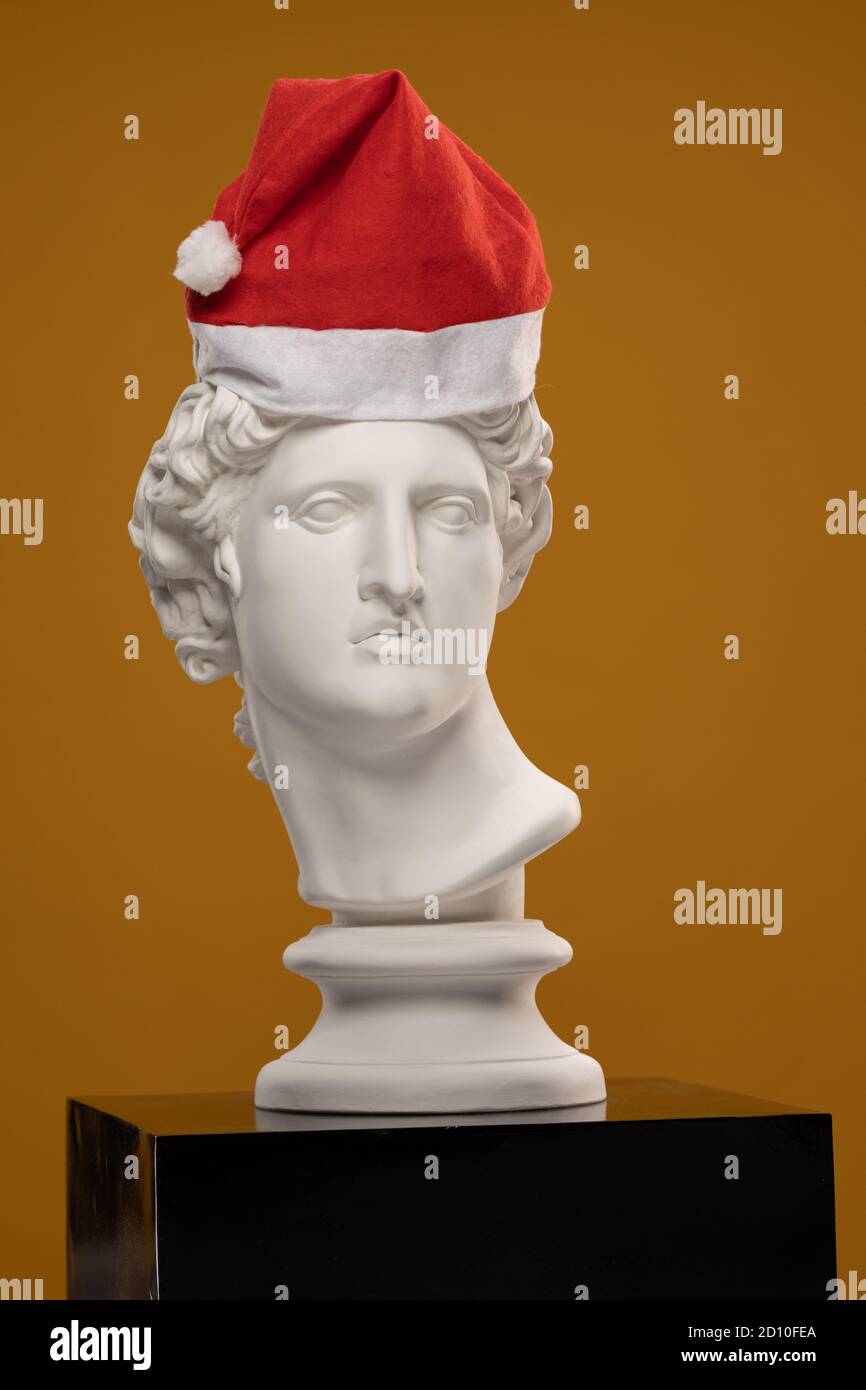 White Plaster Statue of Apollo Belvedere in a red cap of Santa Claus ...