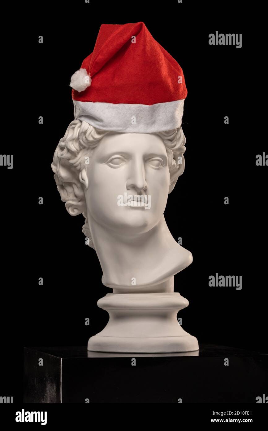 White Plaster Statue of Apollo Belvedere in a red cap of Santa Claus ...