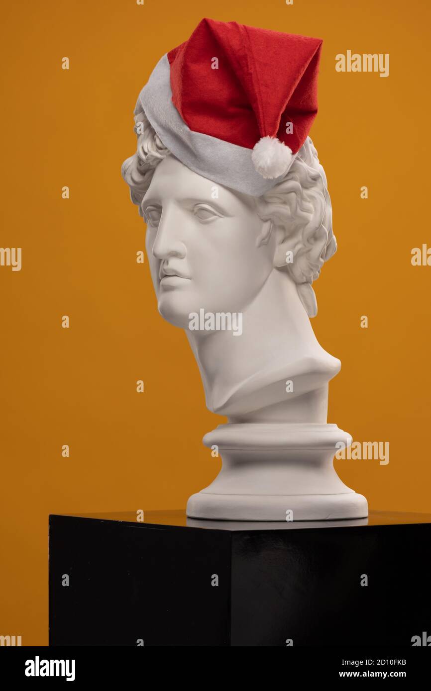 White Plaster Statue of Apollo Belvedere in a red cap of Santa Claus ...