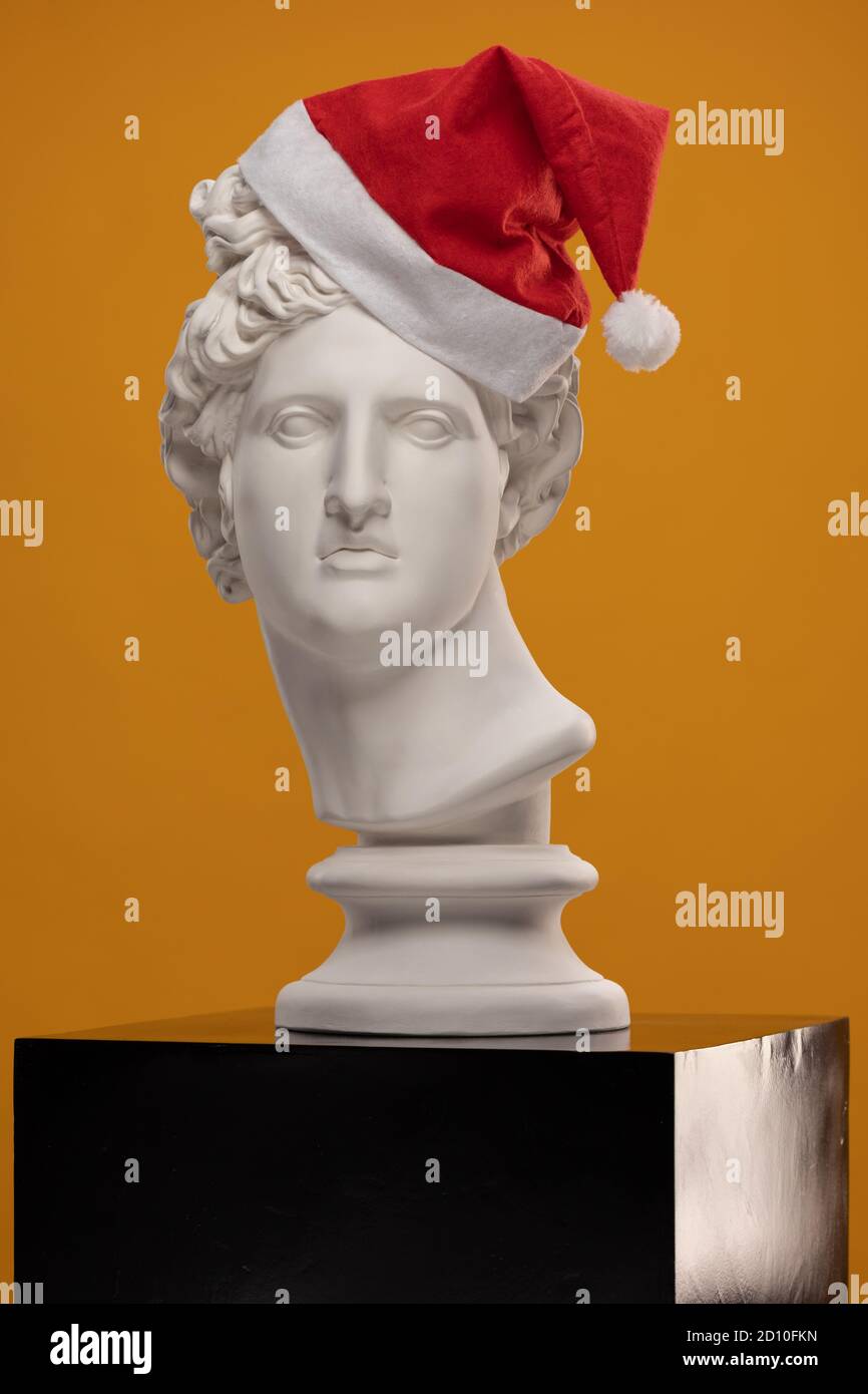 White Plaster Statue of Apollo Belvedere in a red cap of Santa Claus ...