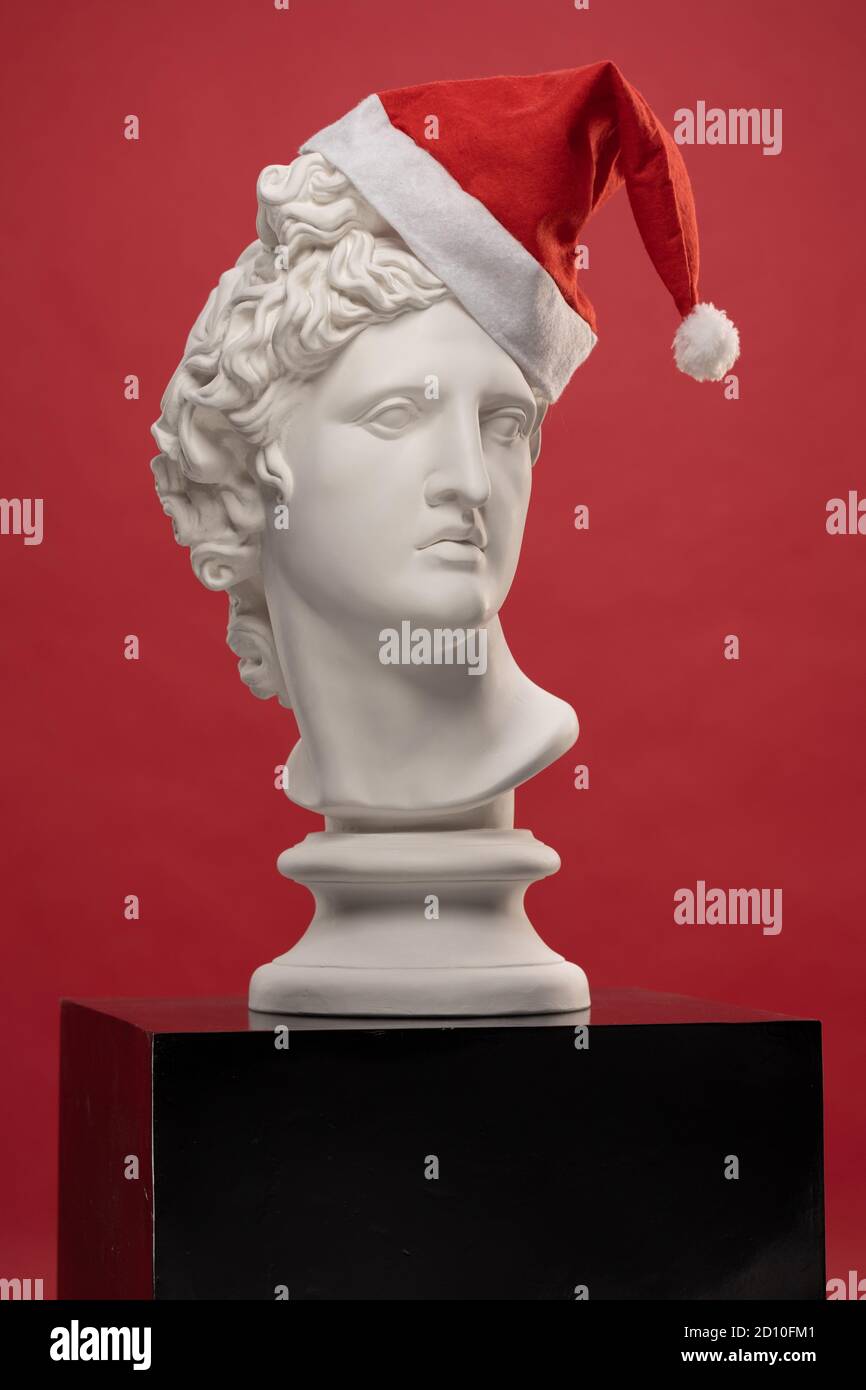 White Plaster Statue of Apollo Belvedere in a red cap of Santa Claus ...