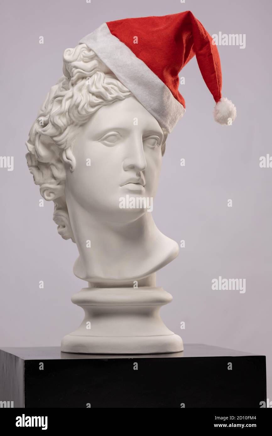 White Plaster Statue of Apollo Belvedere in a red cap of Santa Claus ...