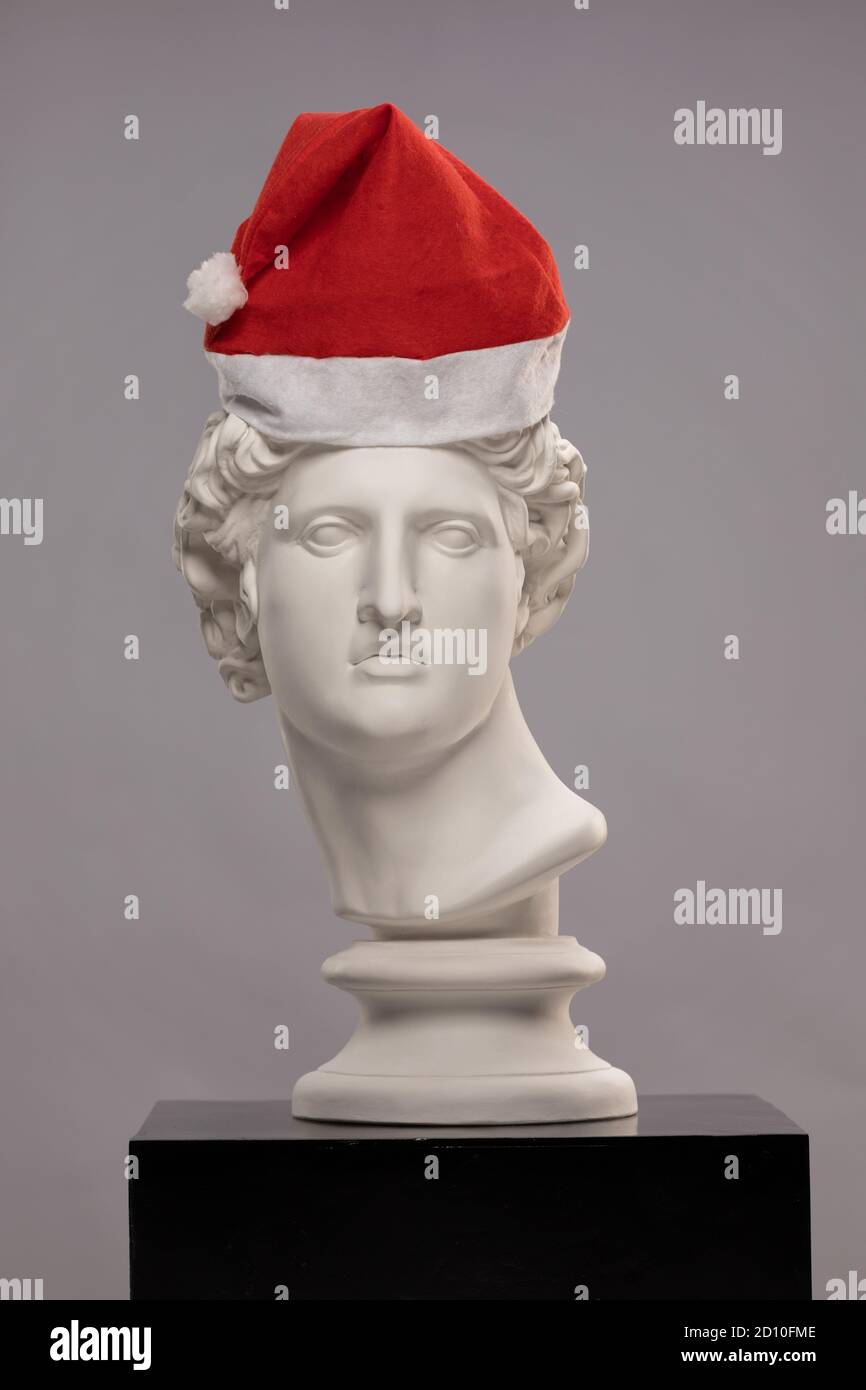 White Plaster Statue of Apollo Belvedere in a red cap of Santa Claus ...