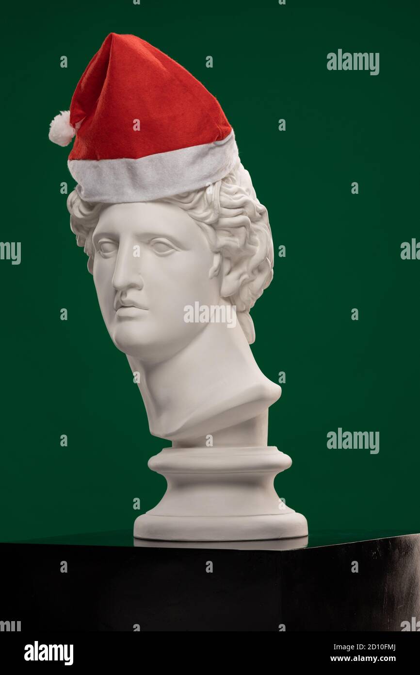 White Plaster Statue of Apollo Belvedere in a red cap of Santa Claus ...